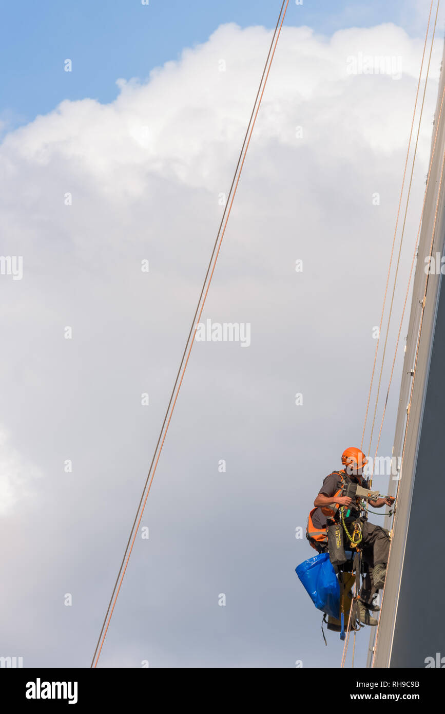 Construction workers apply finishing touches to the new glass ...