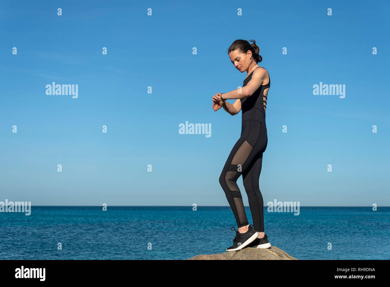 woman runner checking her smart watch Stock Photo - Alamy