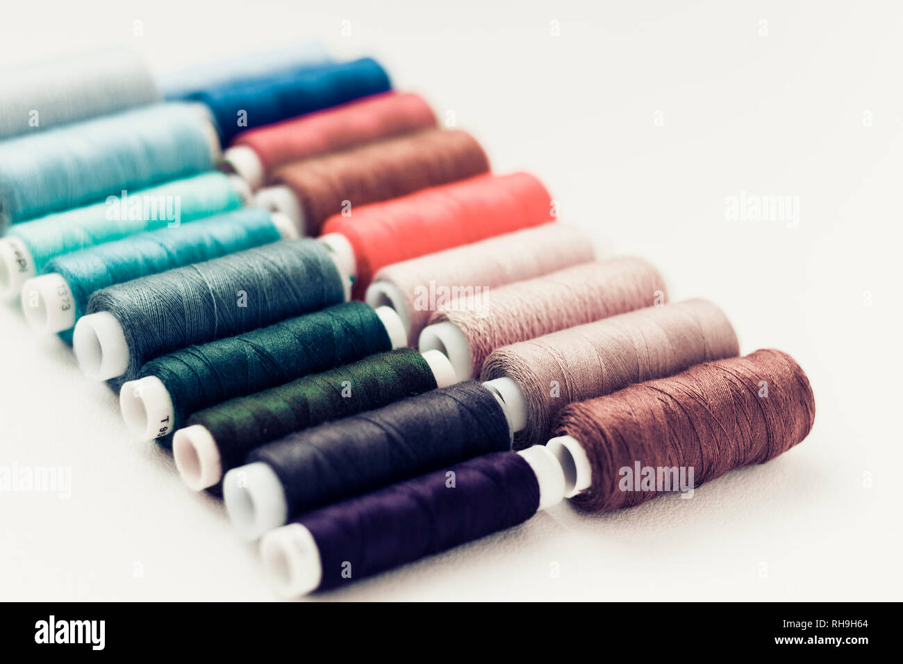 Colored sewing thread coils on white background with copy space for ...