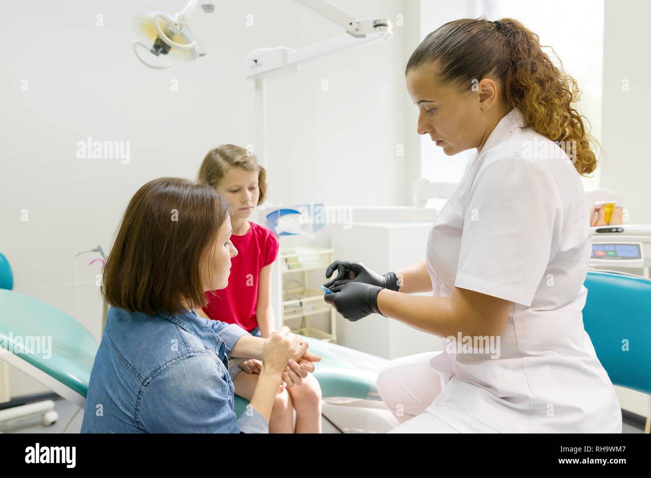 Mother and little daughter visiting dentist at dental clinics ...