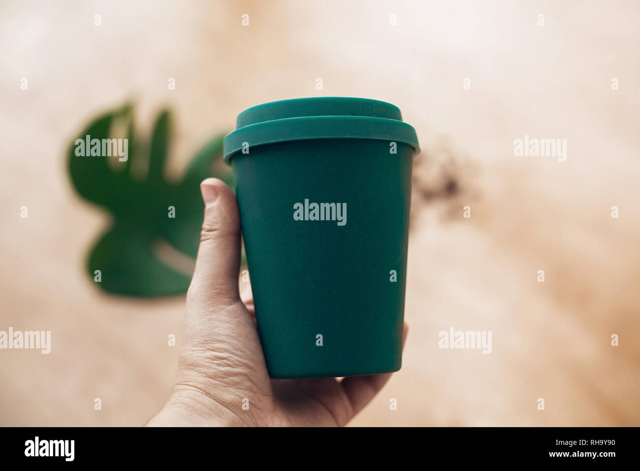 Ban single use plastic. Hand holding eco reusable coffee cup on wooden ...