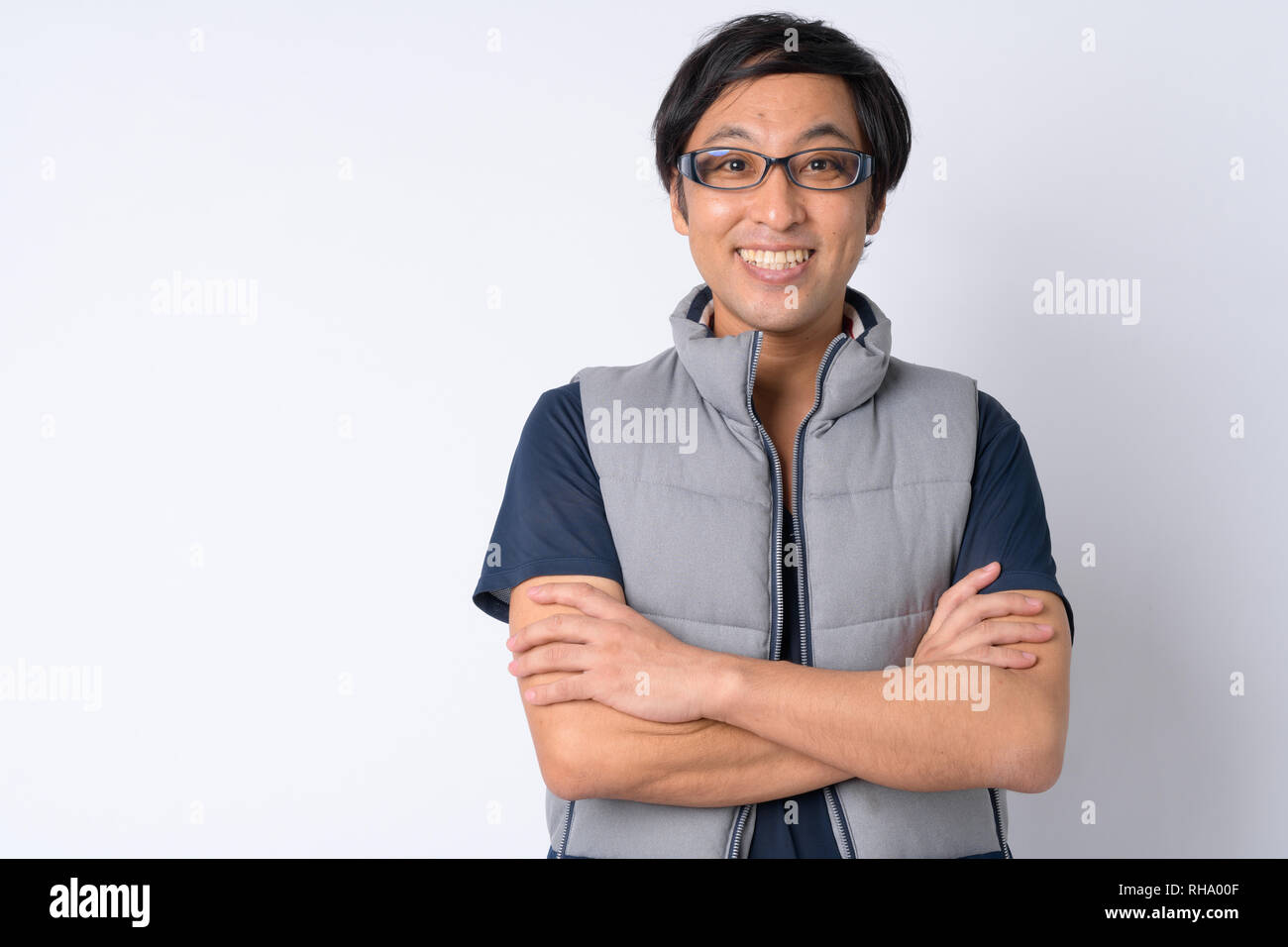 Portrait of happy Japanese man with arms crossed ready for hiking Stock ...