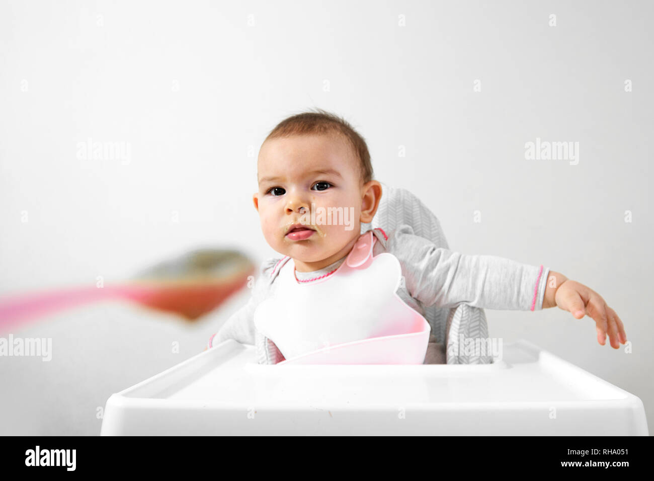 Happy baby toddler in high chair with spoon in his hand Stock Photo - Alamy