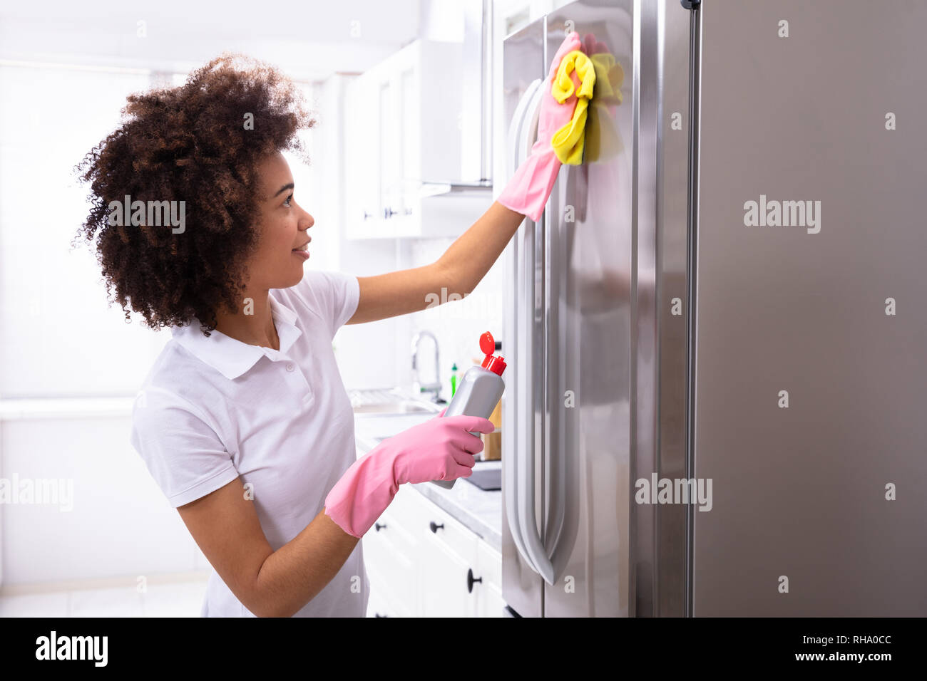 Close-up Of Serious Young Woman Cleaning Refrigerator With Yellow ...