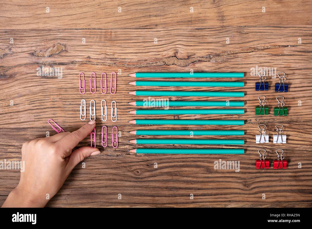 An Overhead View Of A Person's Hand Arranging The Paper Clips And ...