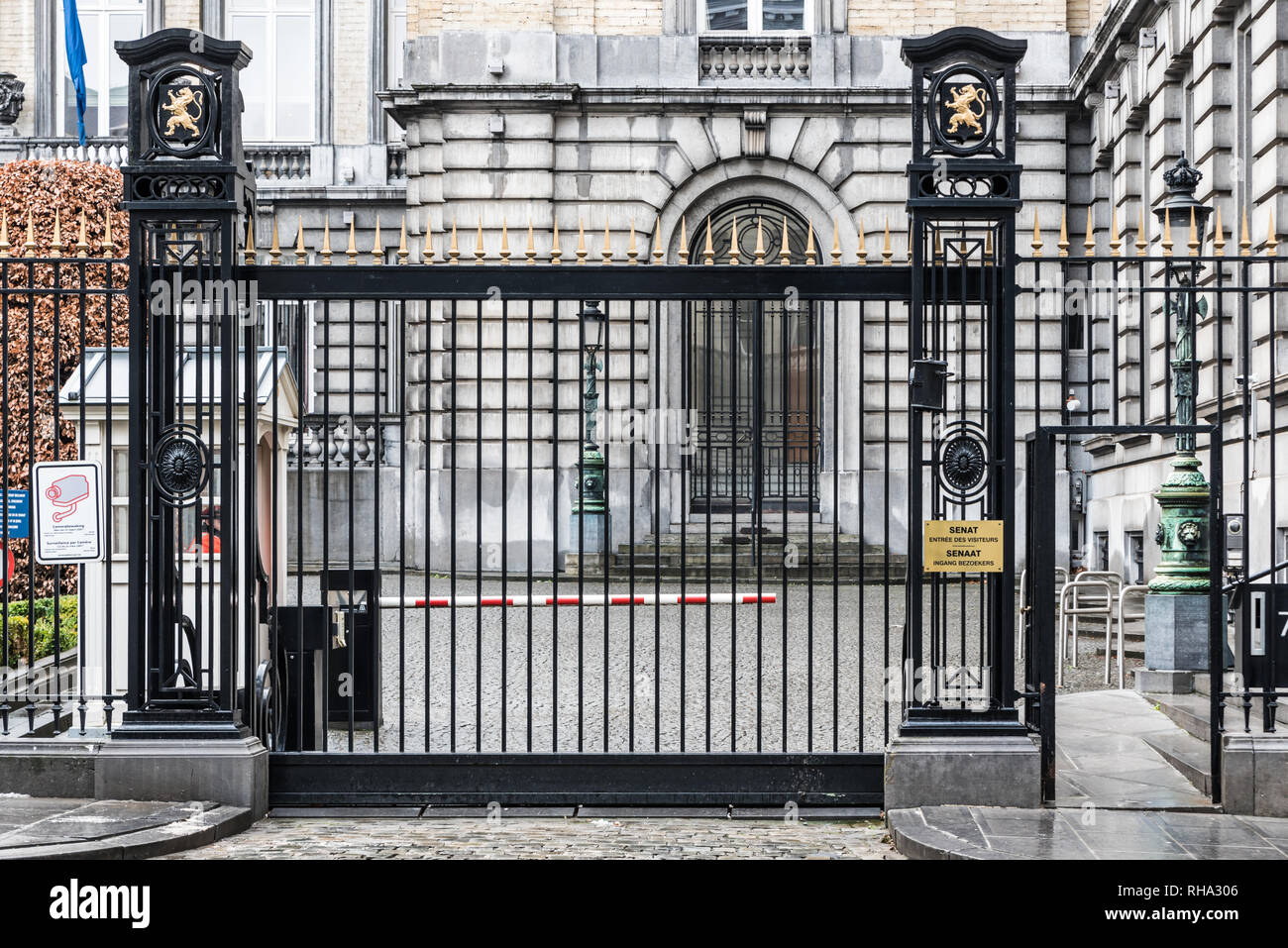 Fence and metal sign, indicating the visitor entrance at the facade of ...