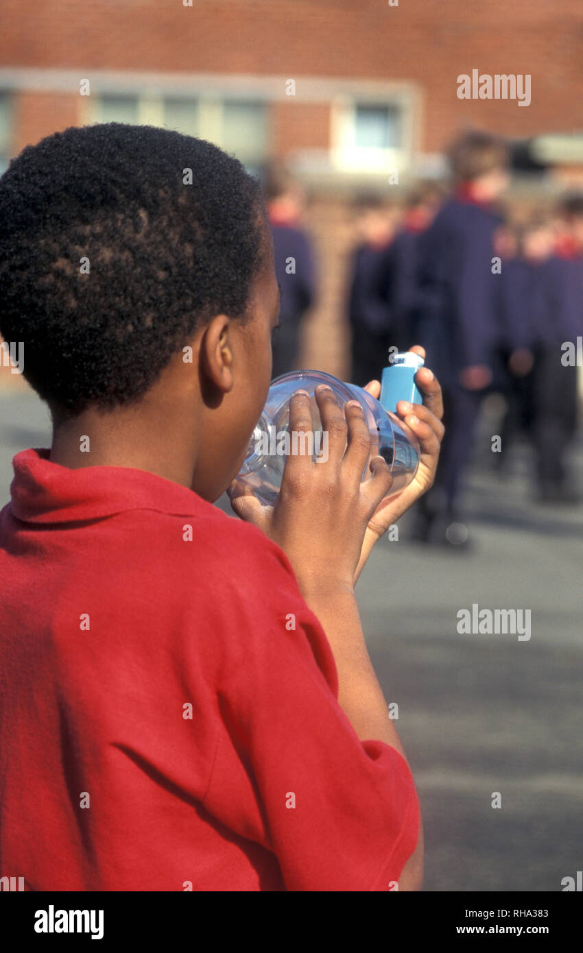 asthmatic black boy using ventolin inhaler attached to spacer in school ...