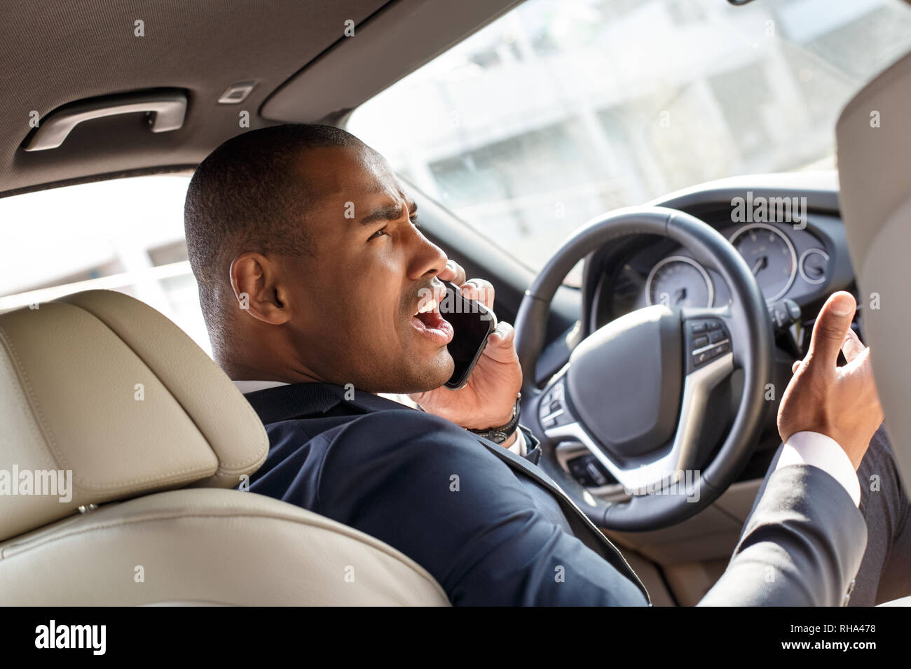 Young mulatto businessman driver sitting inside the car driving ...
