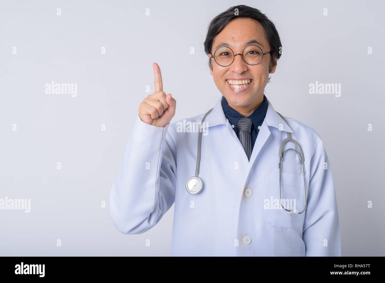 Portrait of happy Japanese man doctor pointing up Stock Photo - Alamy