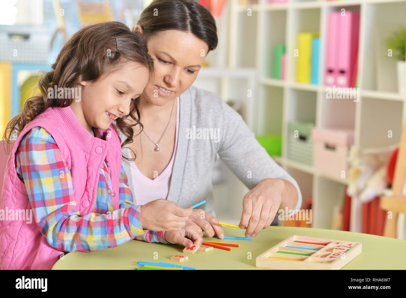 mother with little daughter counting with sticks Stock Photo - Alamy