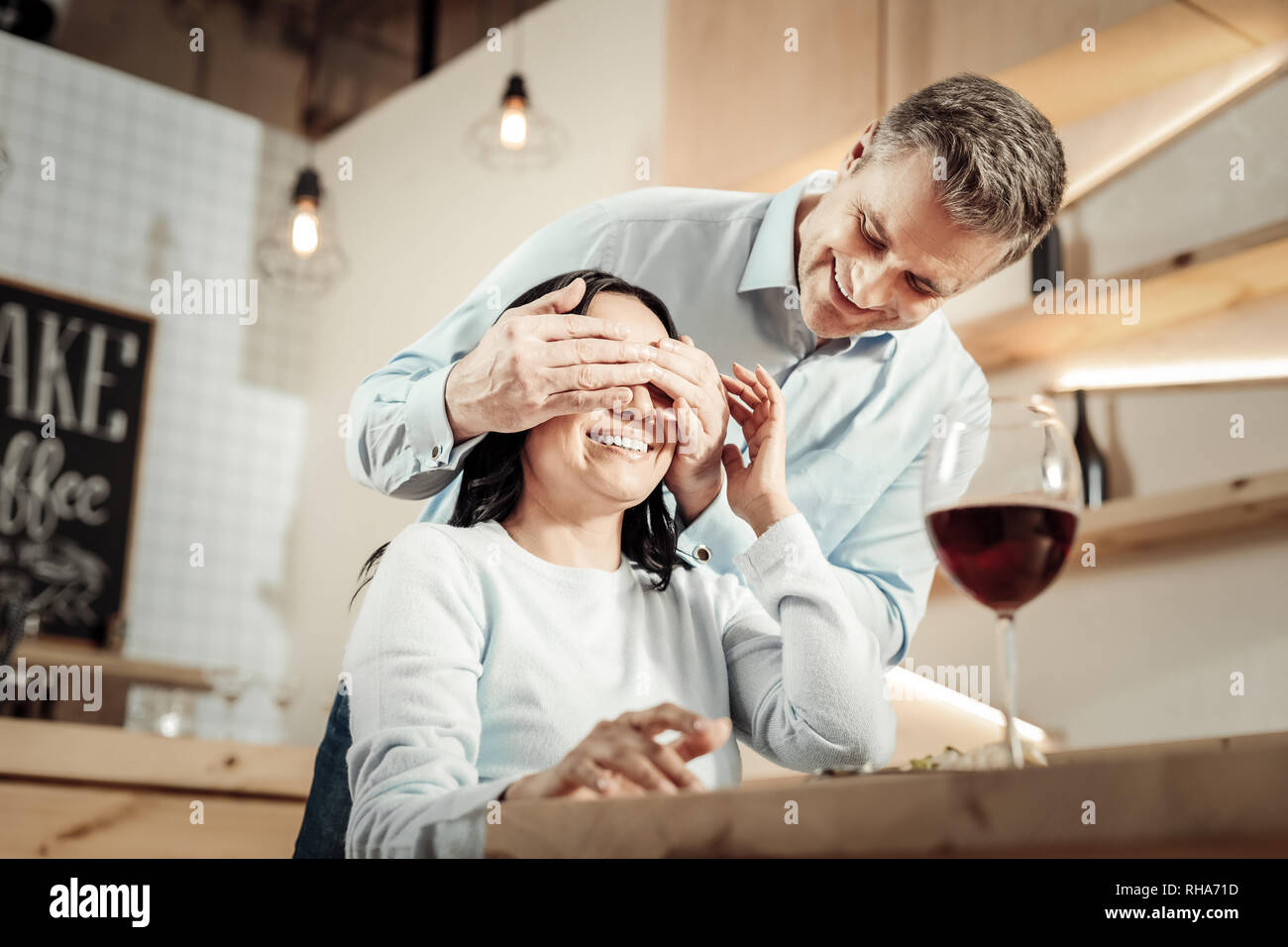 Imposing man covering his womans eyes by hands Stock Photo - Alamy