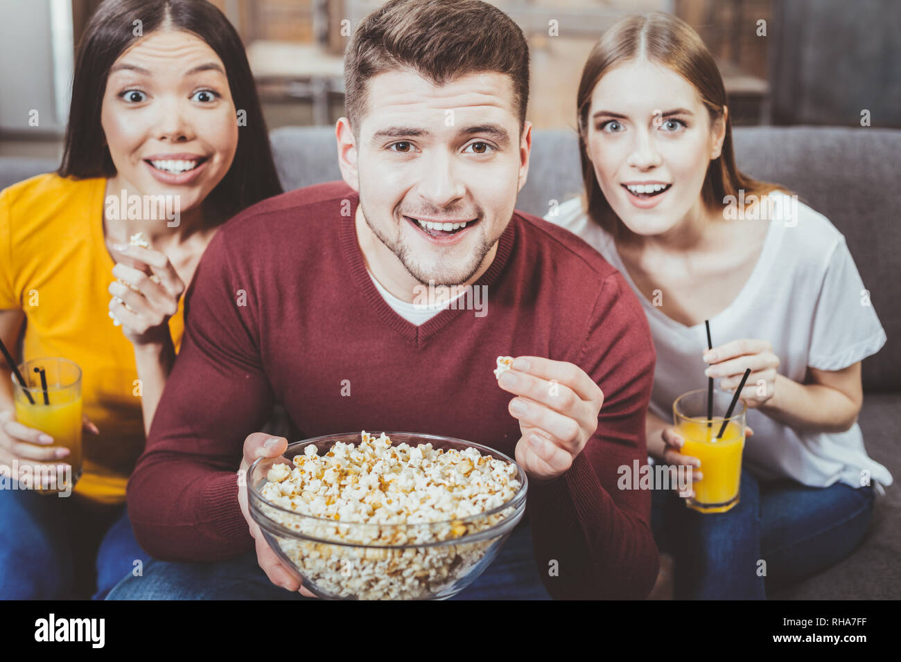 Positive delighted male person eating popcorn Stock Photo - Alamy