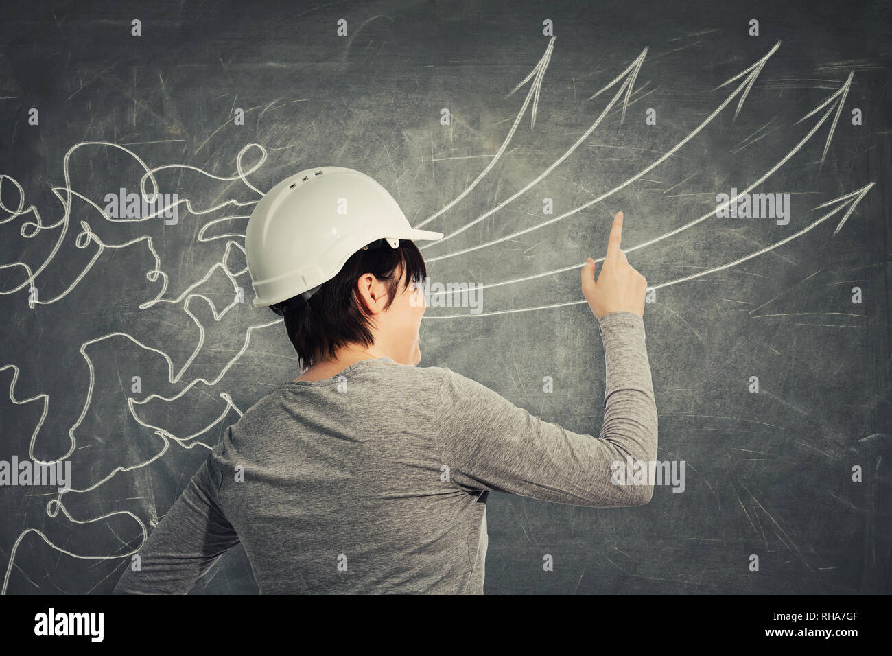 Rear view young woman engineer wearing protective helmet showing at ...