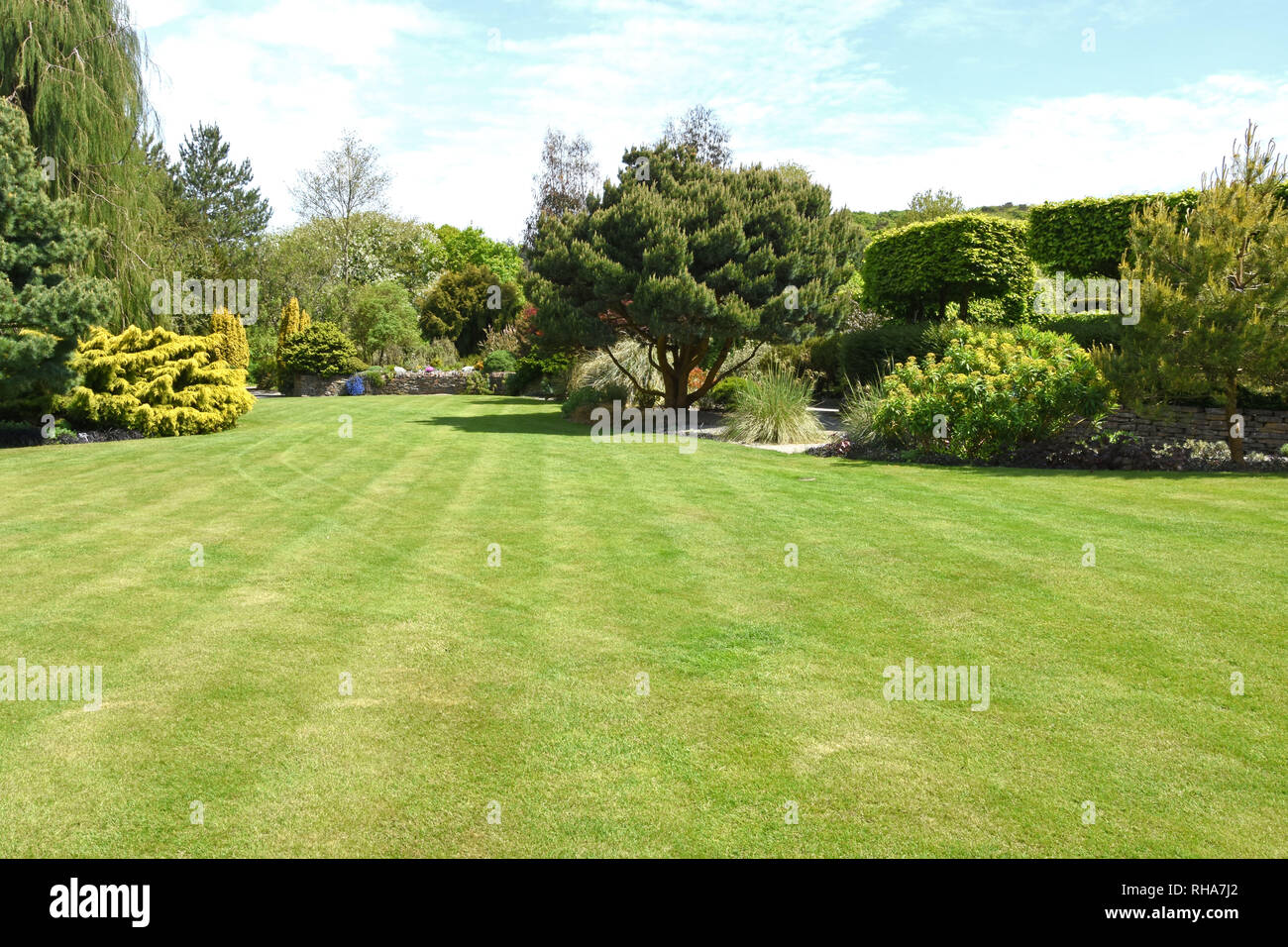 A perfect English country garden with manicured lawn surrounded by ...