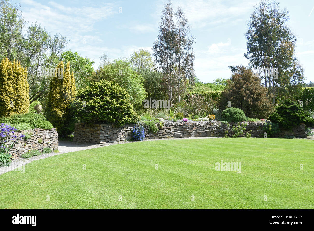 A perfect English country garden with manicured lawn surrounded by ...