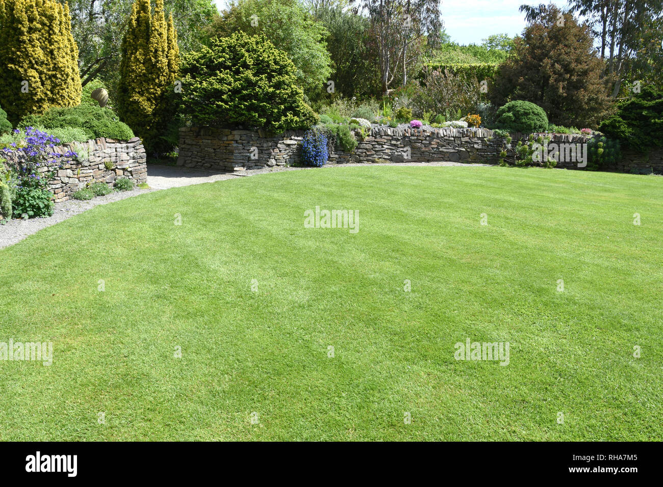 A perfect English country garden with manicured lawn surrounded by ...