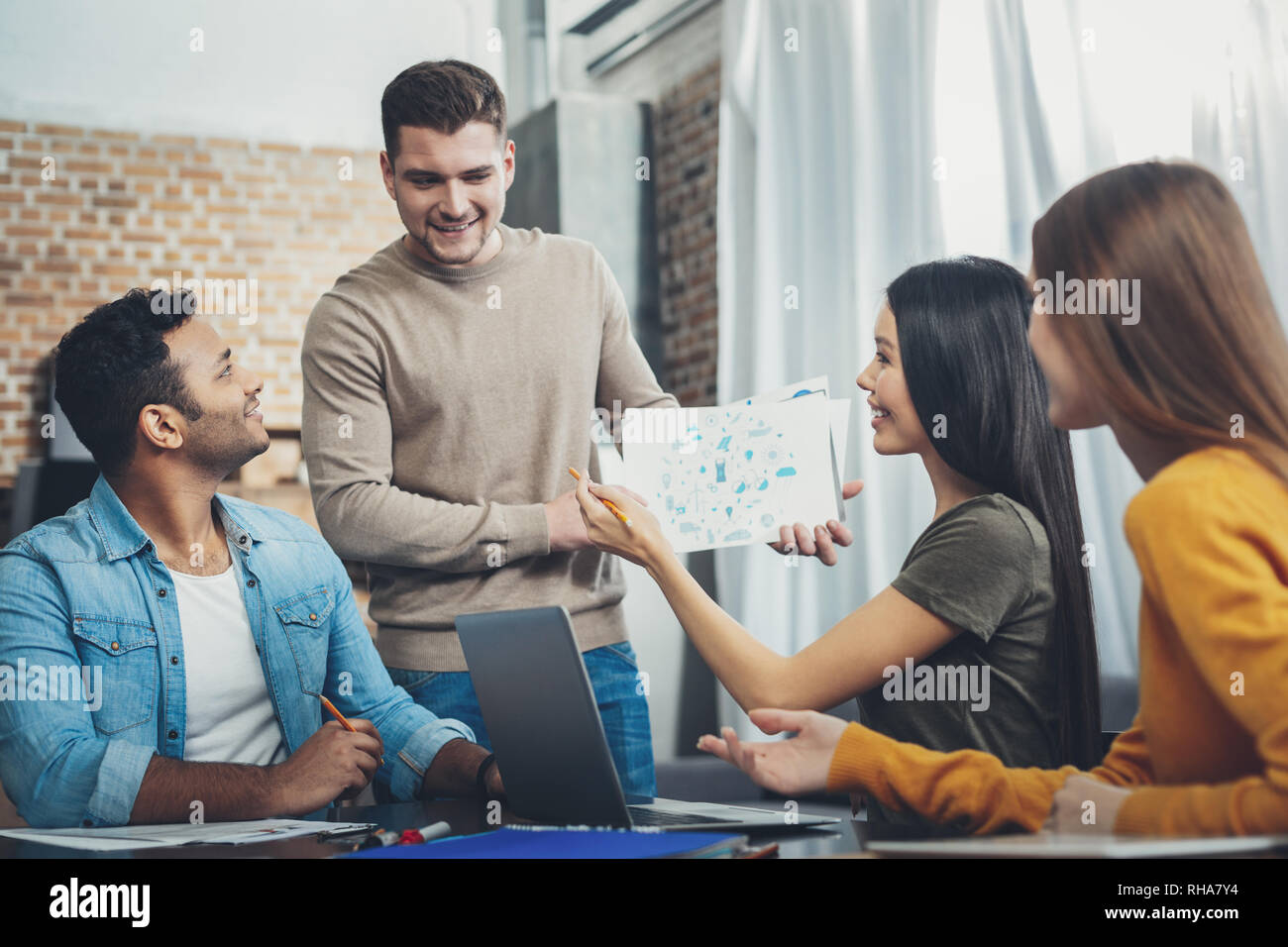Happy four students preparing presentation Stock Photo - Alamy