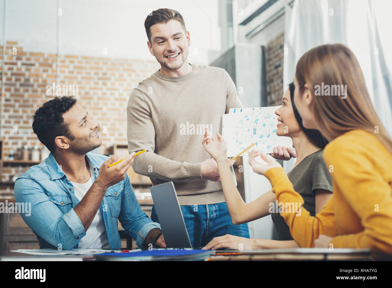 Jolly four students exchanging ideas Stock Photo - Alamy