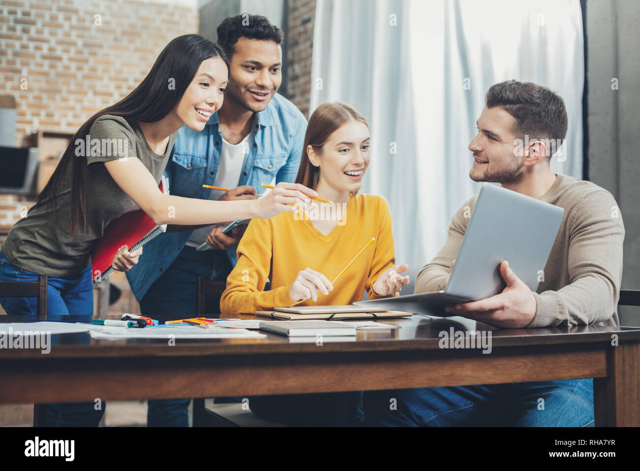 Jolly four students finding solution Stock Photo - Alamy