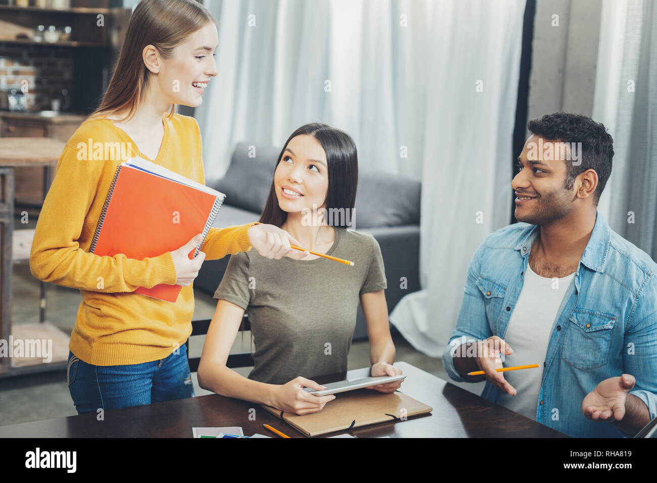 Enthusiastic three students introducing ideas Stock Photo - Alamy