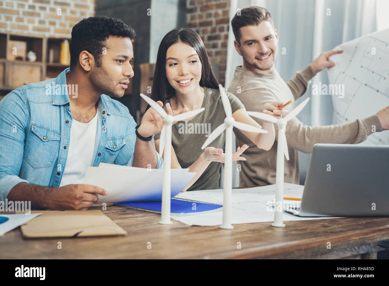 Optimistic three colleagues implementing wind power Stock Photo - Alamy