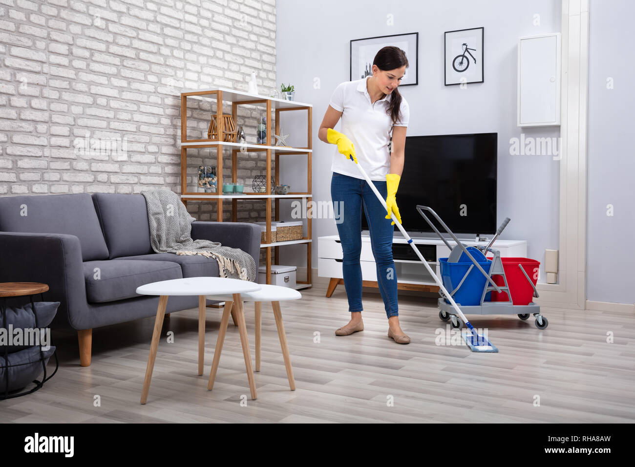 Female Janitor Cleaning Floor With Mop In Living Room Stock Photo - Alamy