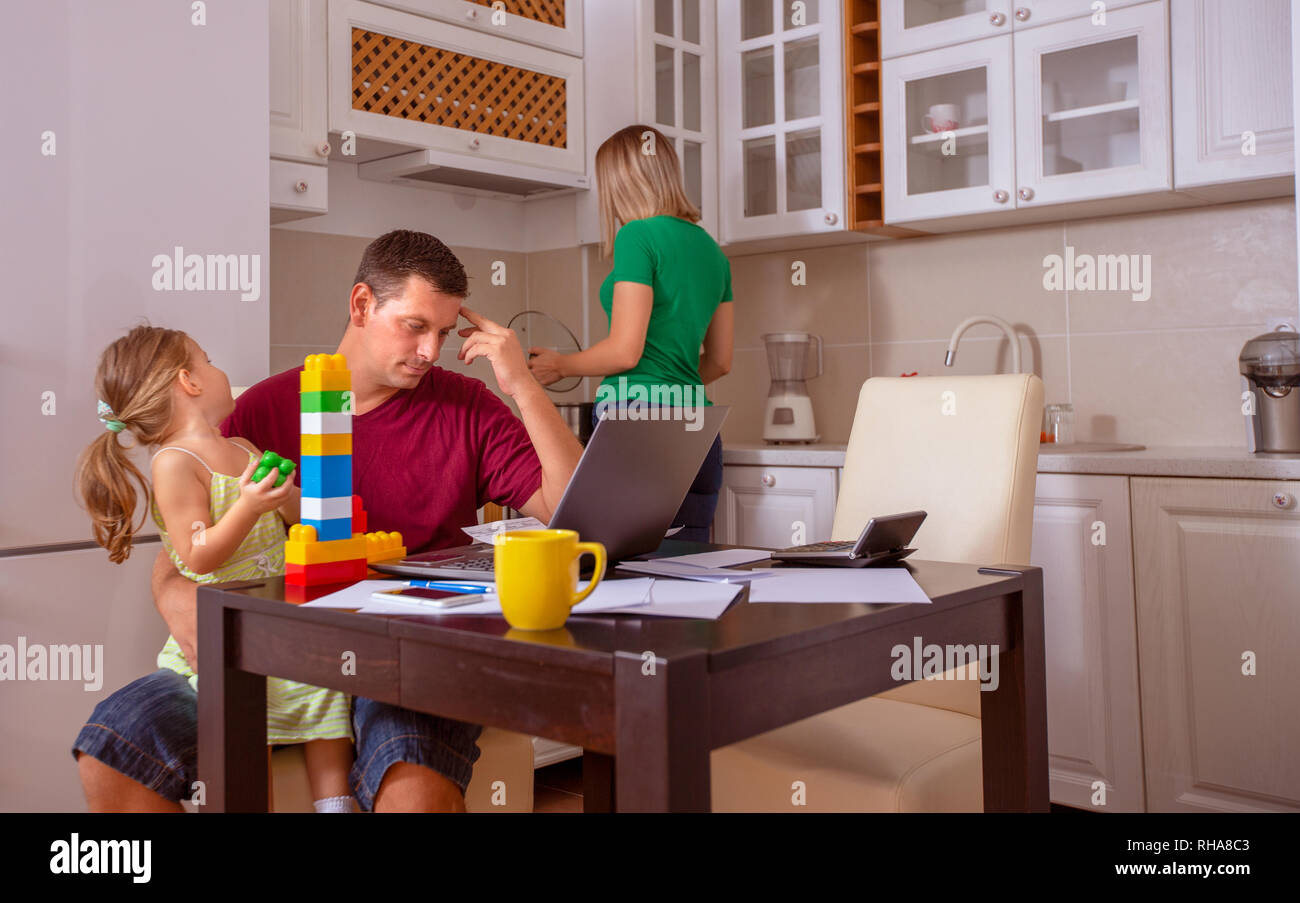 Busy Family Home with Young Father Working as Mother Prepares Meal ...
