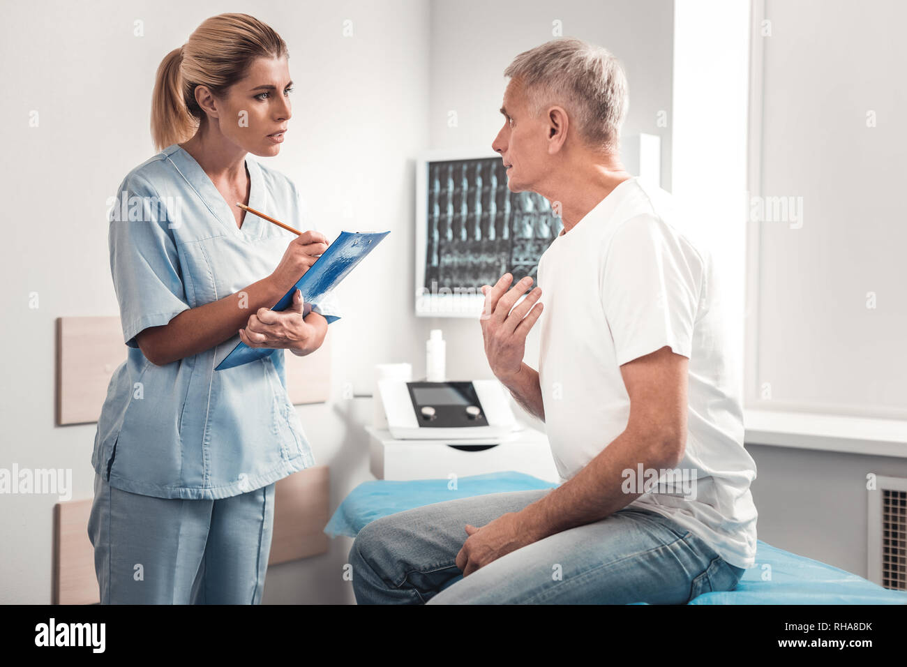 Caring blue-eyed nurse listening to patient attentively Stock Photo - Alamy