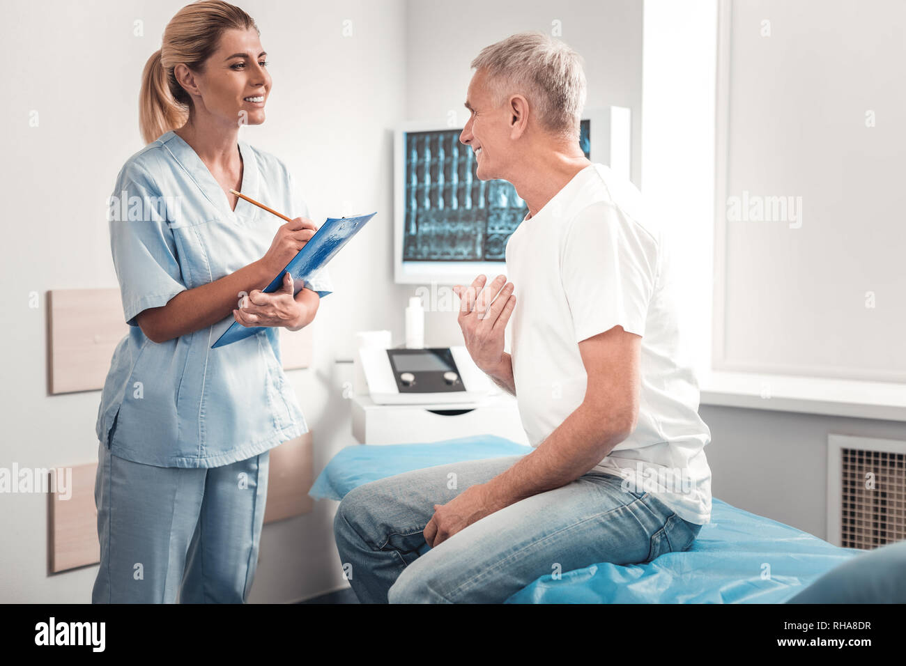 Beautiful medical assistant enjoying communication with visitor Stock ...