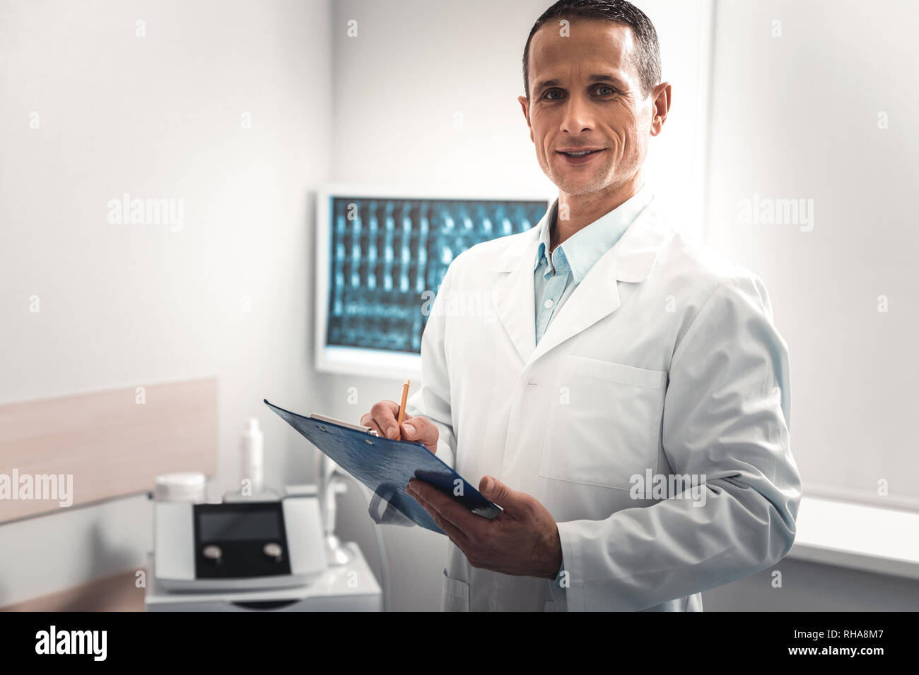 Dark-haired doctor making some important notes Stock Photo - Alamy
