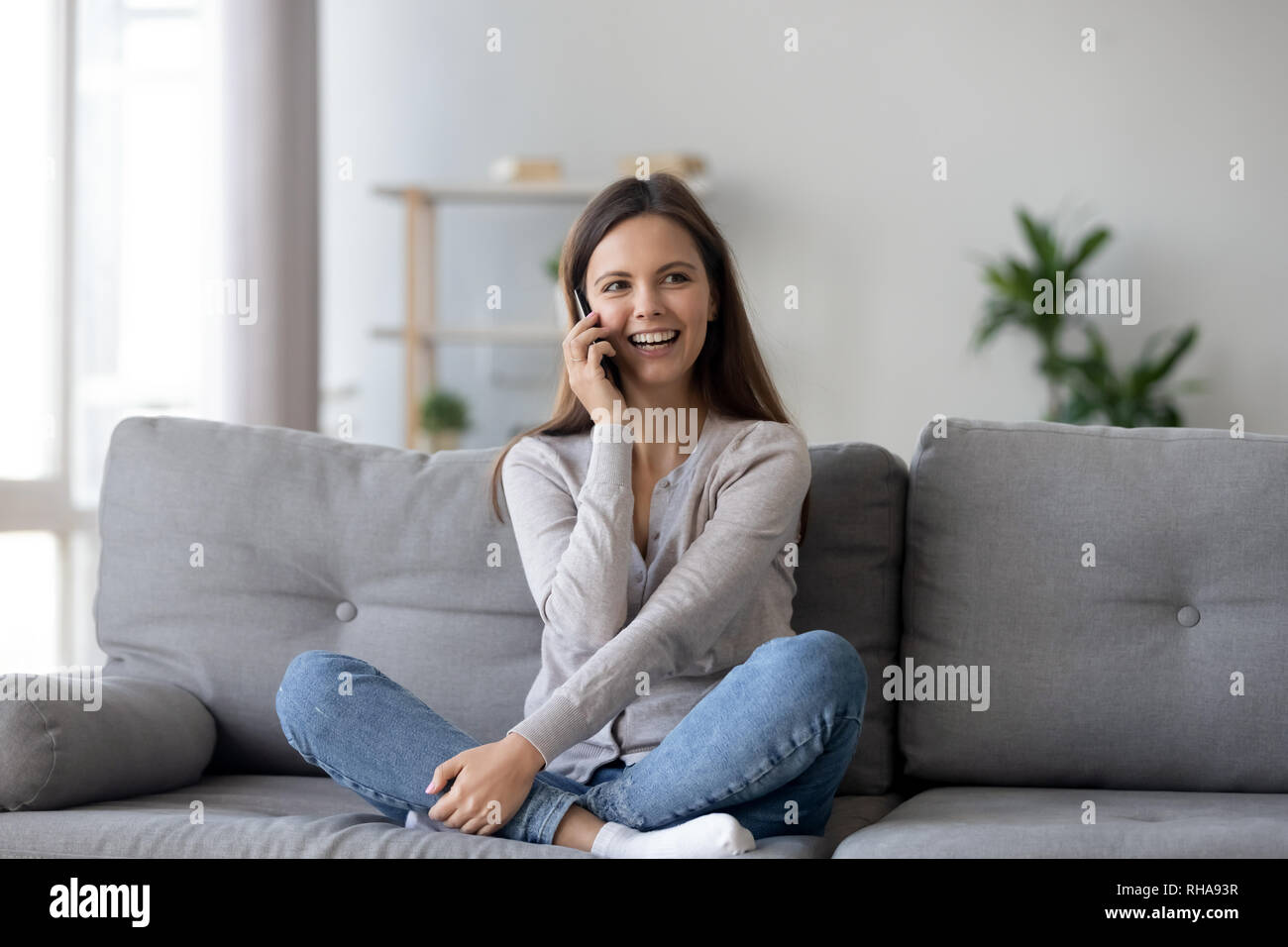 Happy young woman caller talking on the phone at home Stock Photo - Alamy