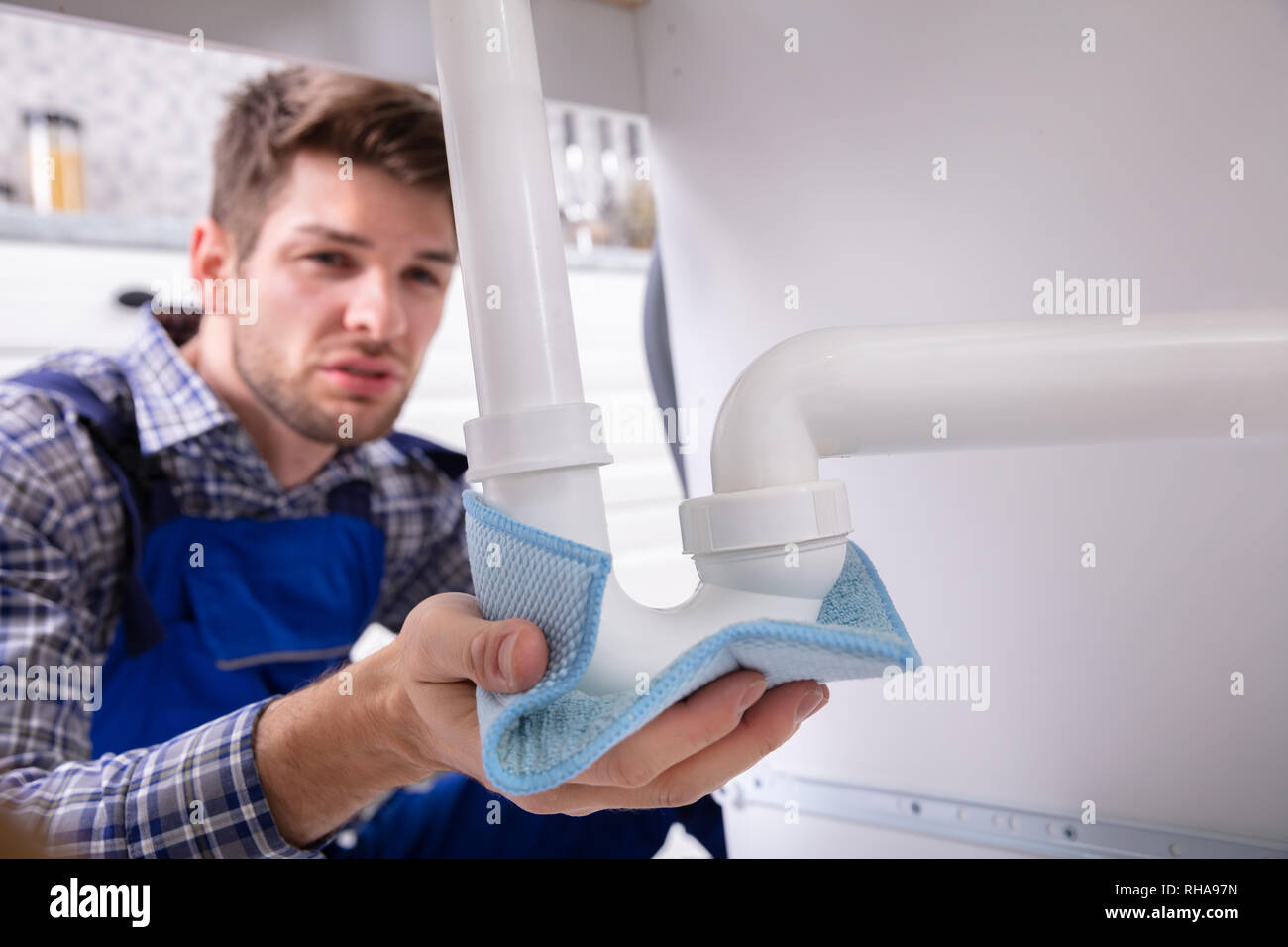 Close-up Of A Male Plumber Holding Blue Napkin To Stop Sink Pipe ...