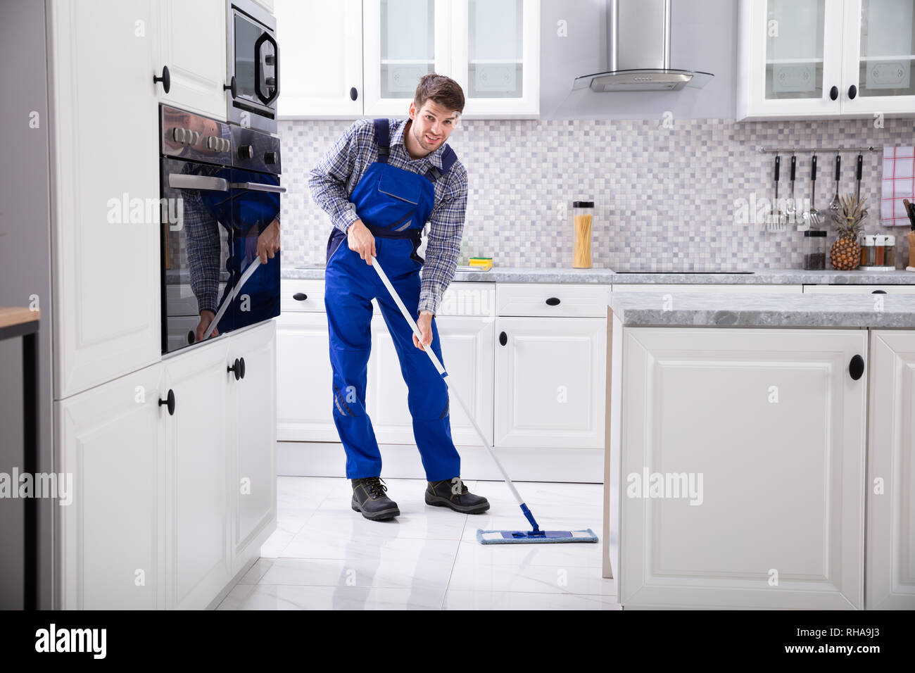 Smiling Male Janitor Cleaning Floor With Mop In Kitchen Stock Photo - Alamy