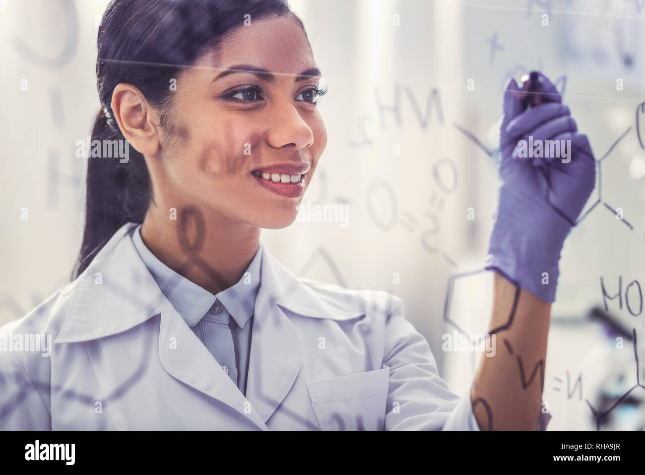 Appealing dark-haired chemist writing chemical formula Stock Photo - Alamy