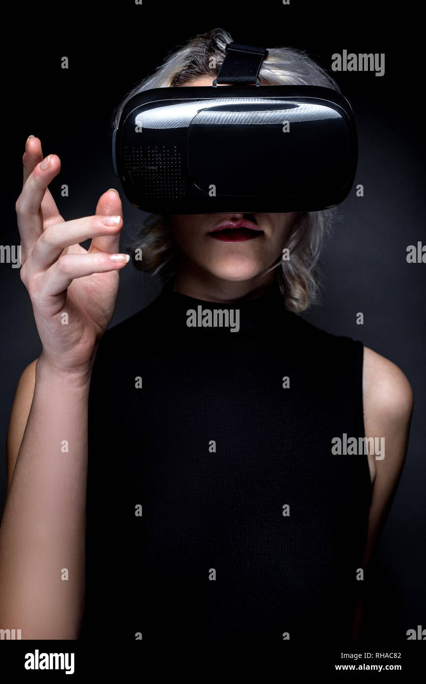Woman wearing a futuristic looking virtual reality headset goggles. The ...