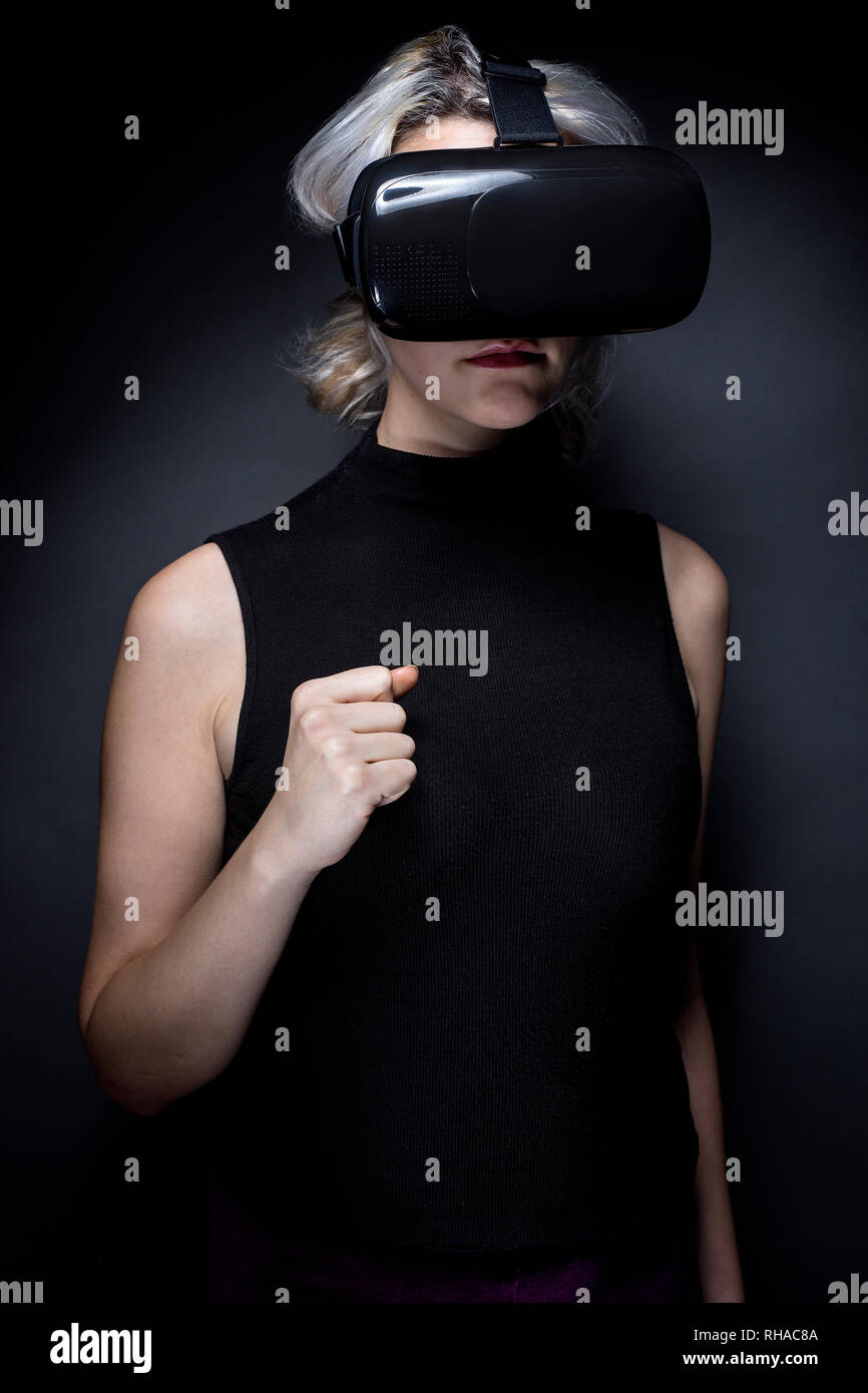 Woman wearing a futuristic looking virtual reality headset goggles. The ...