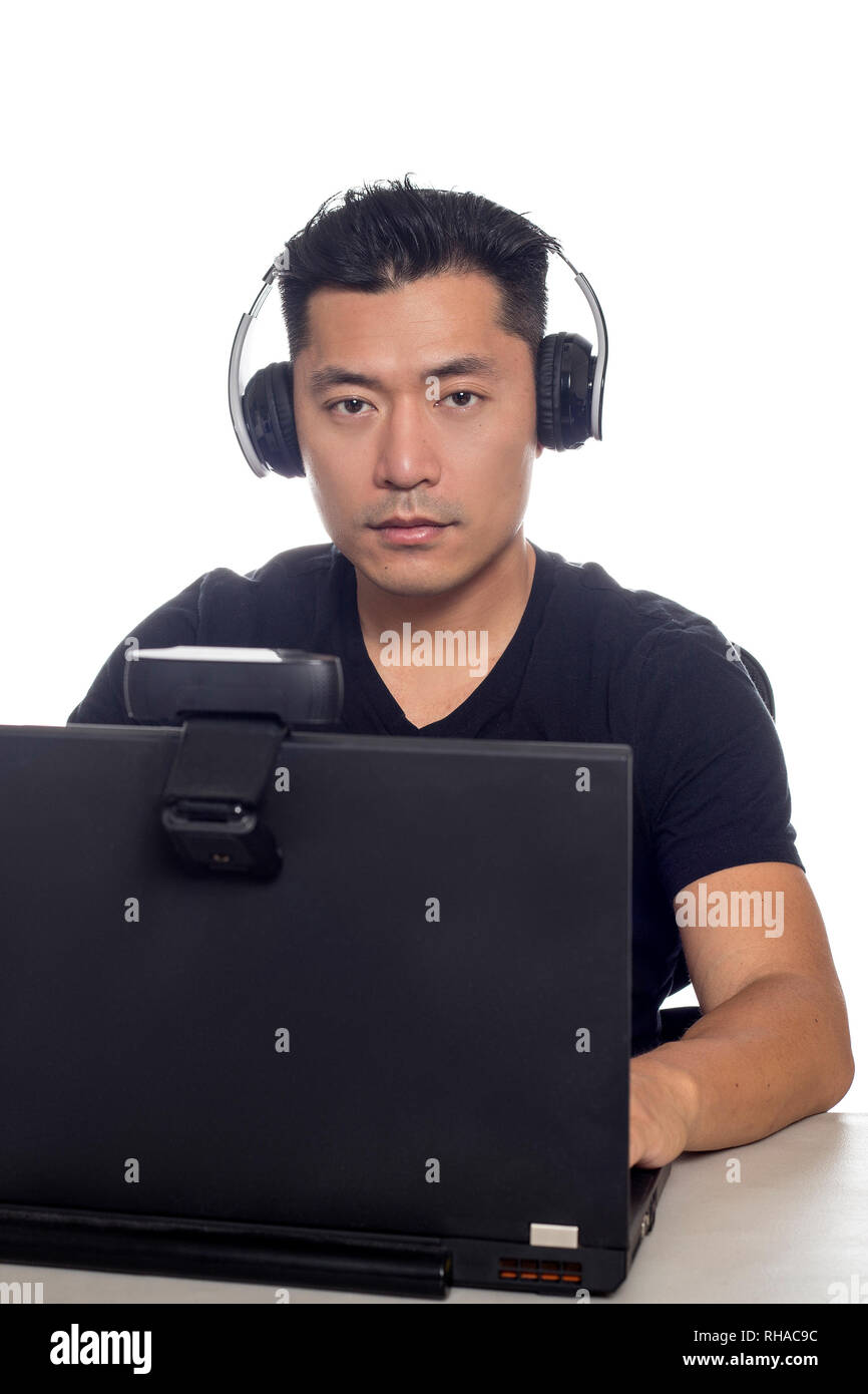 Asian male wearing headphones playing a video game and streaming online ...