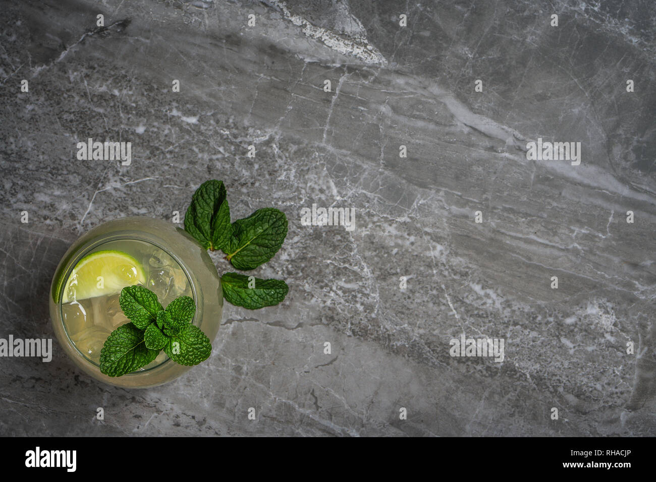 An overhead photograph of a glass of mojito cocktail with ice on a ...
