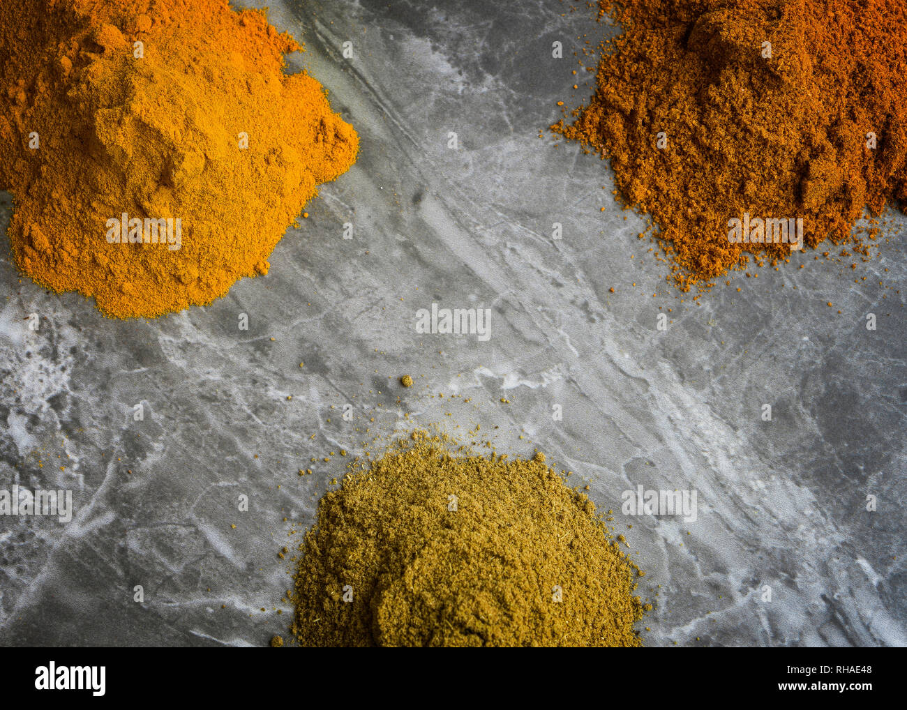 Dried mixed organic spice powders on a marble kitchen worktop ...