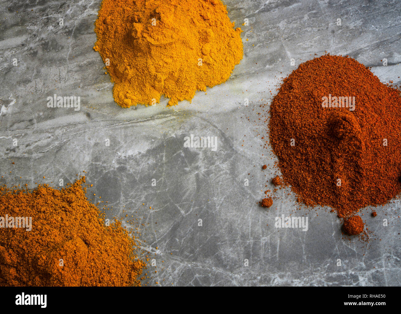 Dried mixed organic spice powders on a marble kitchen worktop ...