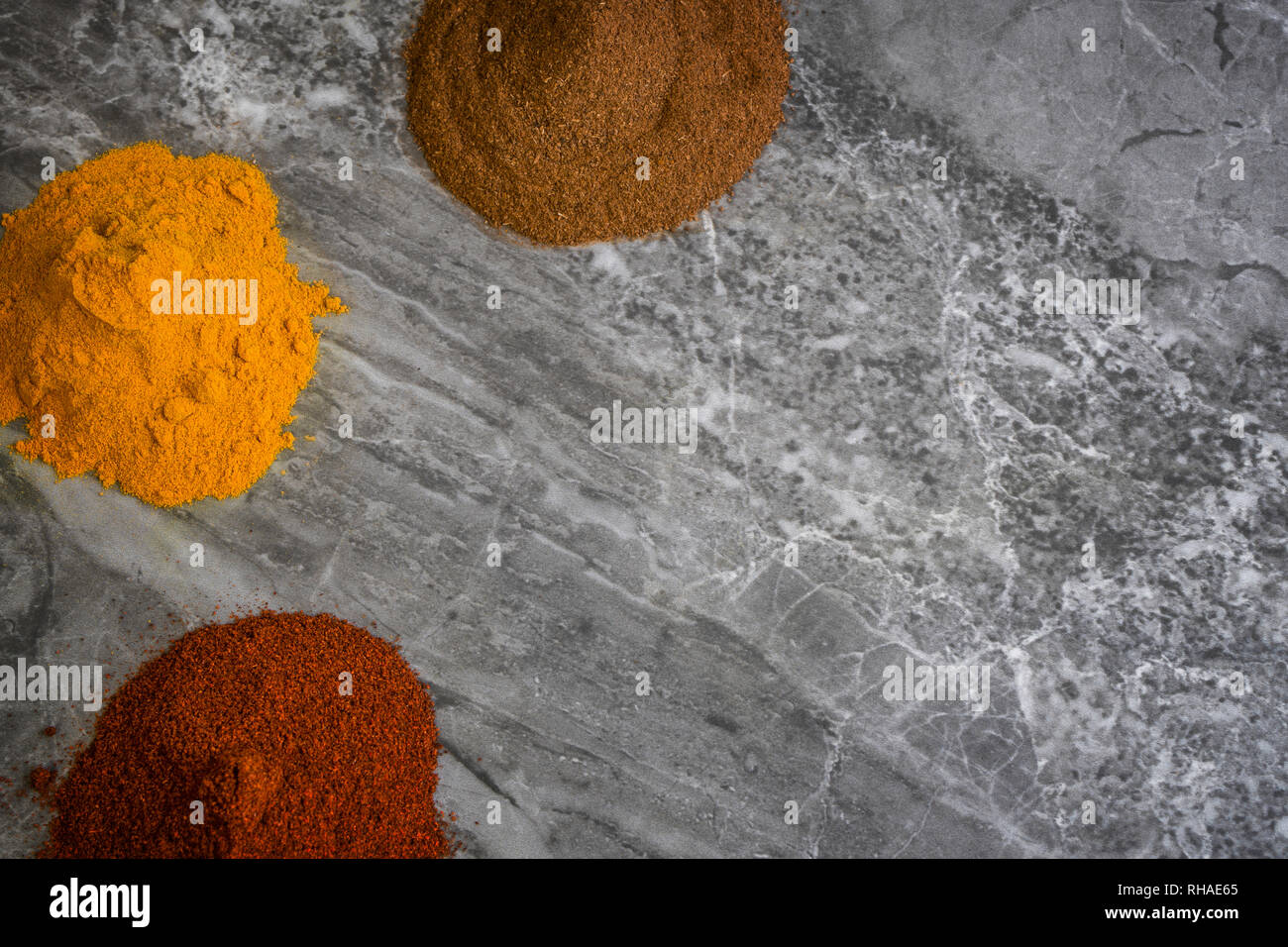 Dried organic spice powders on a marble kitchen worktop background ...
