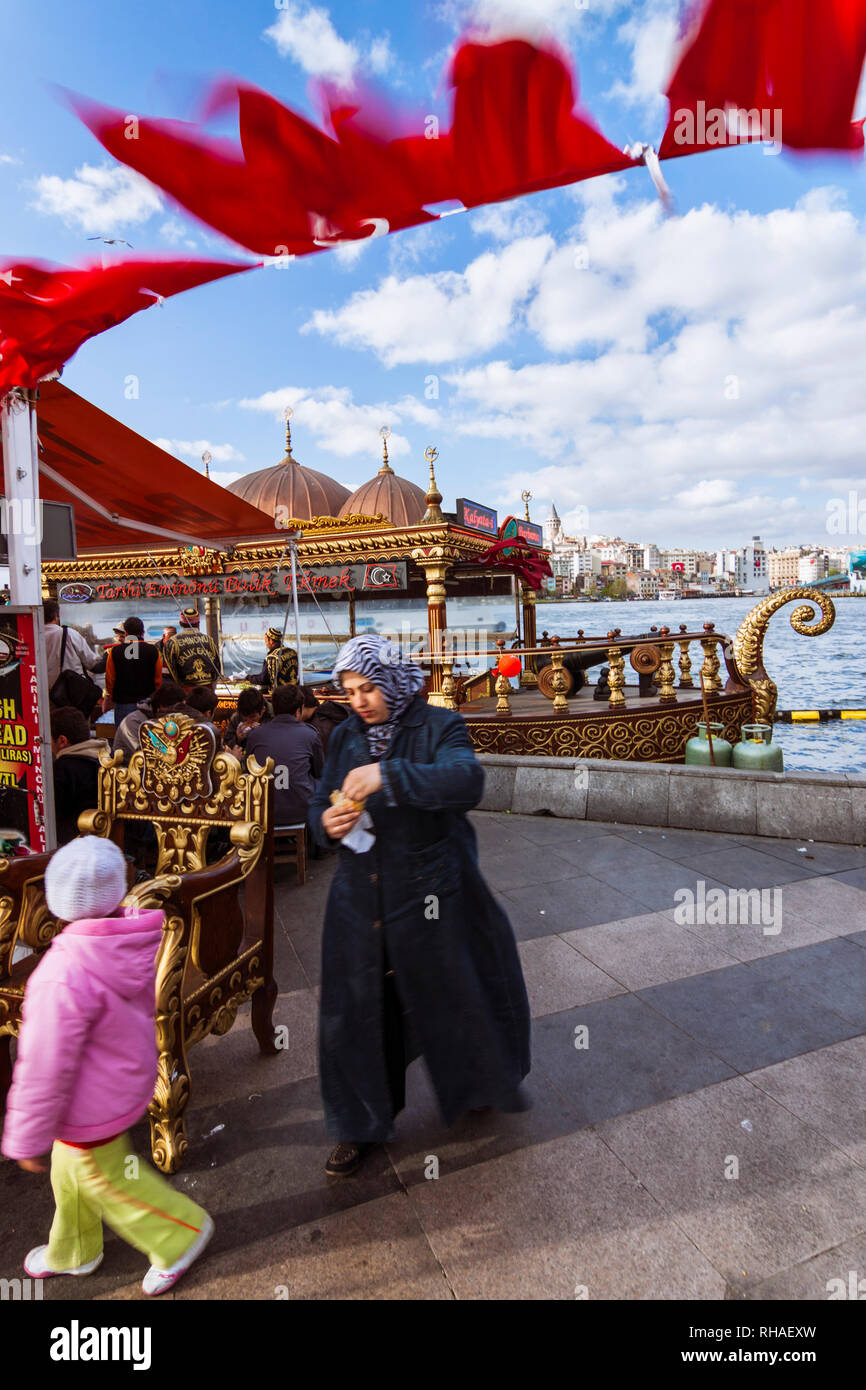 Istanbul, Turkey : A woman and a child walk past a fish kebab floating ...