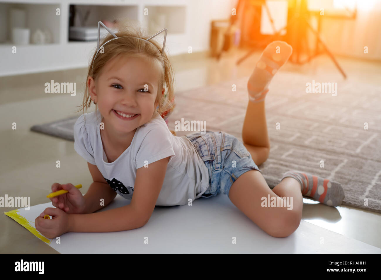 Happy child. Photo look side creative girls lying near books and toys ...