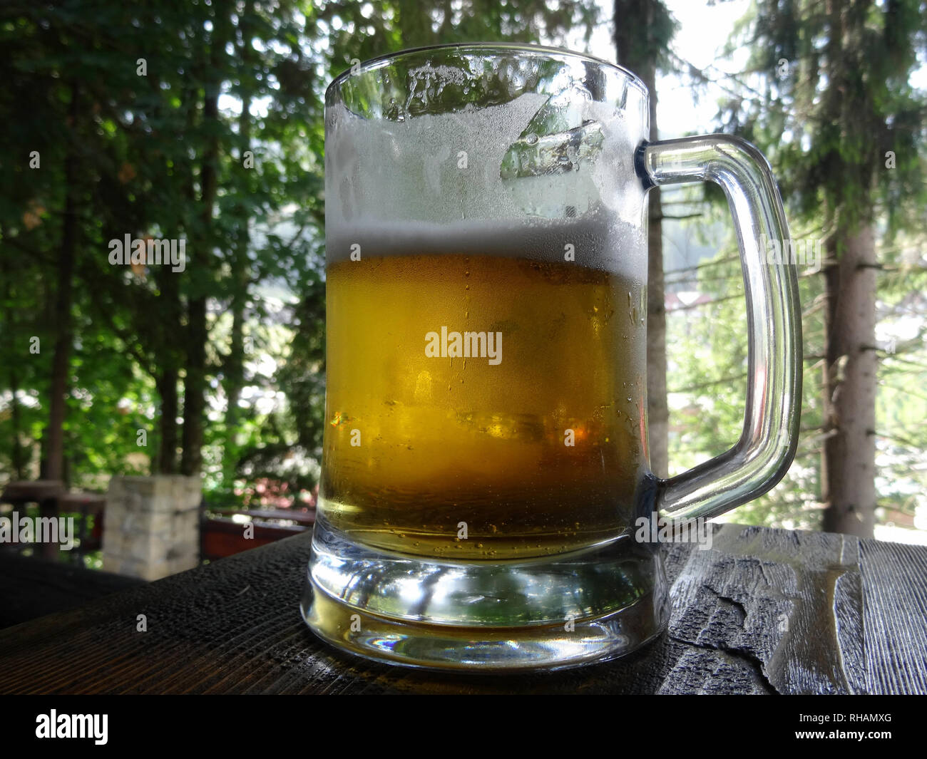 Glass of frothy craft beer in a cold beer mug Stock Photo - Alamy