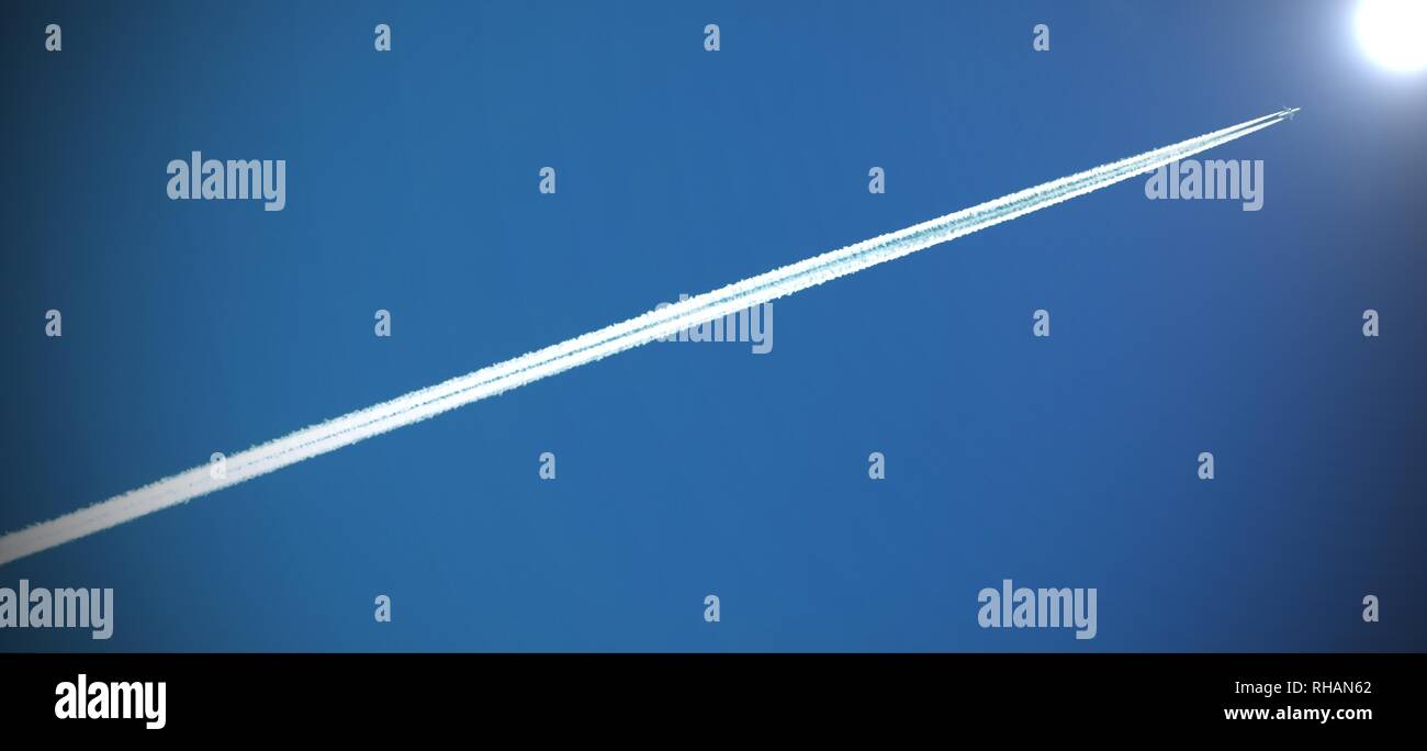 Engine exhaust white contrails forming behind an aircraft with toned ...