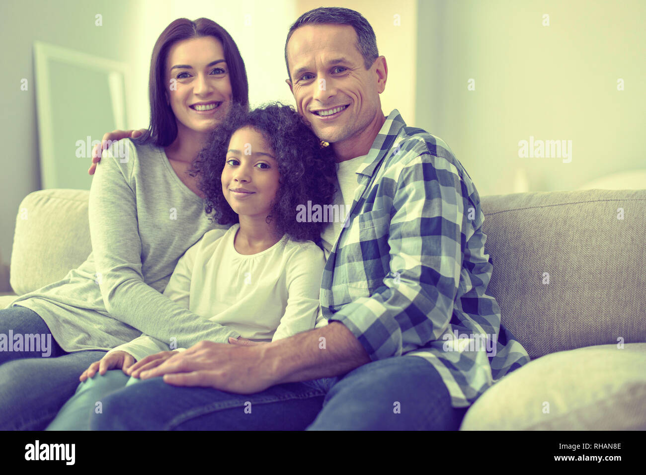 Smiling happy parents hugging their beautiful daughter Stock Photo - Alamy