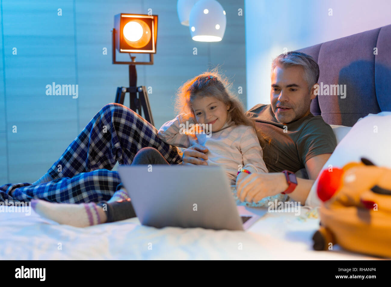 Grey-haired handsome father in a dark t-shirt and his daughter looking ...