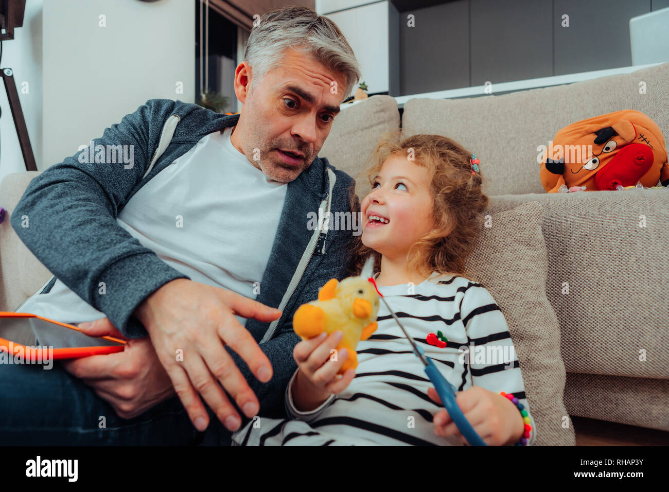 Handsome grey-haired tall father with a red watch on his hand looking ...