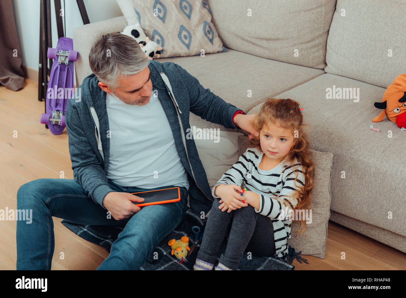 Handsome grey-haired tall father with a red watch on his hand looking ...