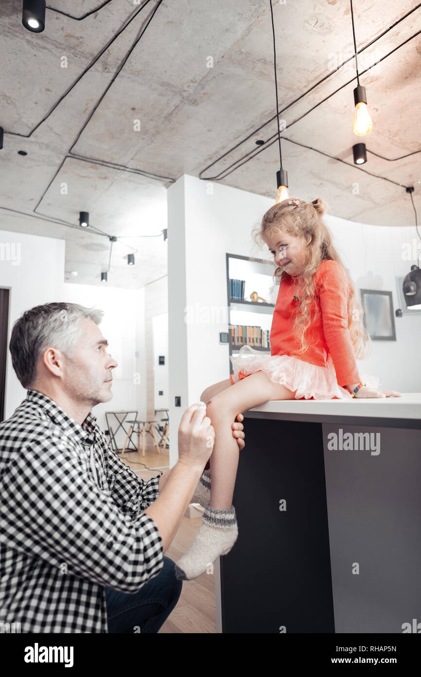Grey-haired tall father in a checkered shirt looking concentrated Stock ...